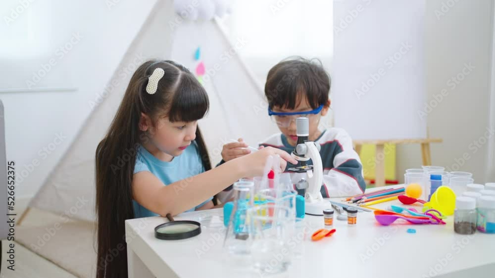 Kid playing a microscope for scientific experiments at home.Young ...