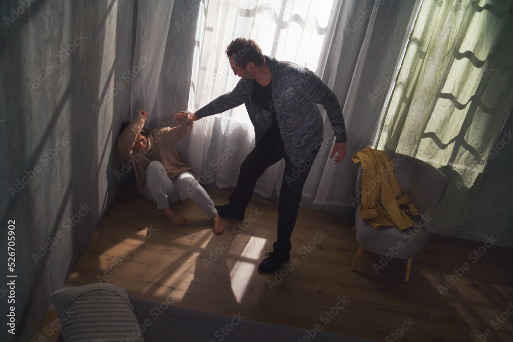 Scared woman being abused on ground by her husband at home. Stock Photo ...