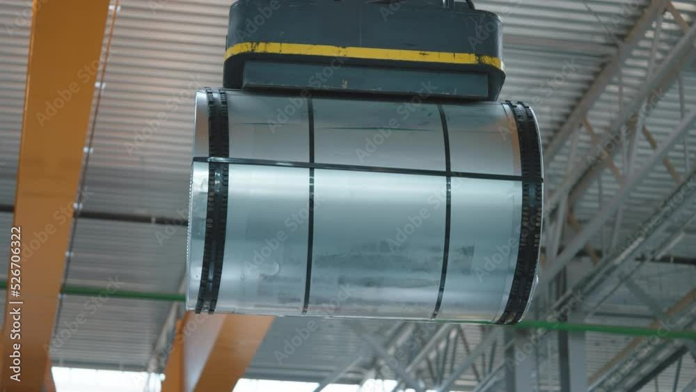 Loading sheet metal in a warehouse using a crane and an electromagnet ...