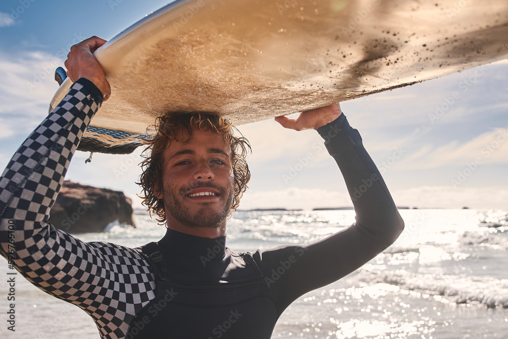 Surfer man athlete with wet hair holding surfboard at the head on ...