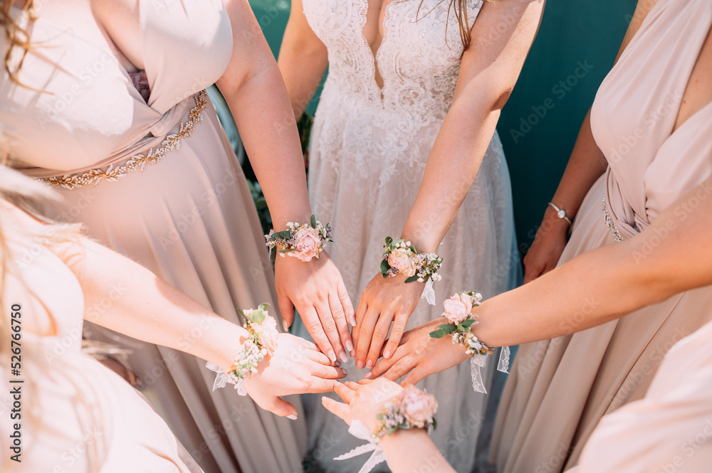 Trauzeuginnen auf einer Hochzeit zeigen Hände mit Armschmuck in ...