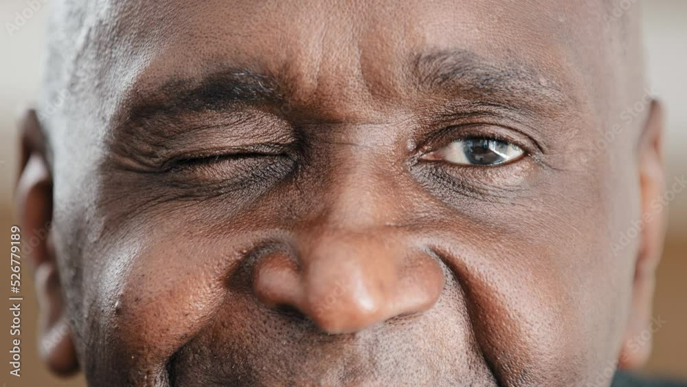 Extreme close-up male wrinkled face with dark skin eyes looking at ...