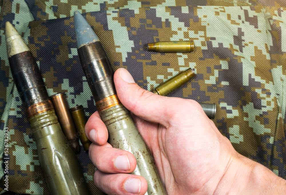 Soldier hold Bullets, shells, cartridges and projectiles on khaki ...