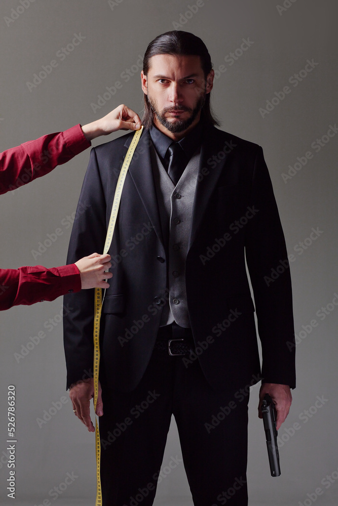 Tailor measuring arm length of bespoke suit. Looking like John Wick ...