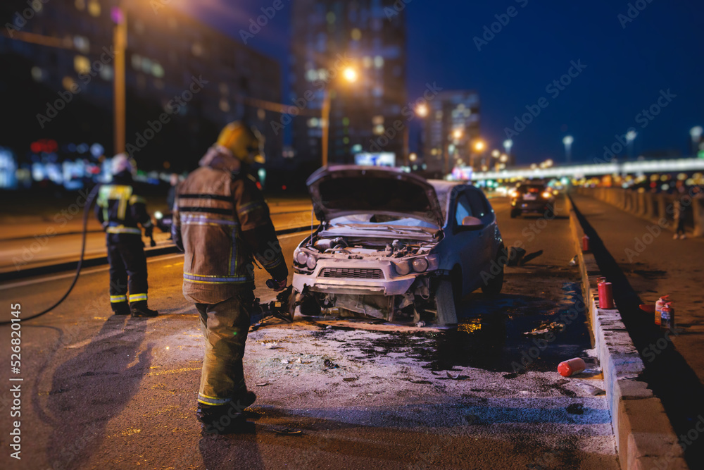 Group of fire men extinguishing and put out burning car crash after ...