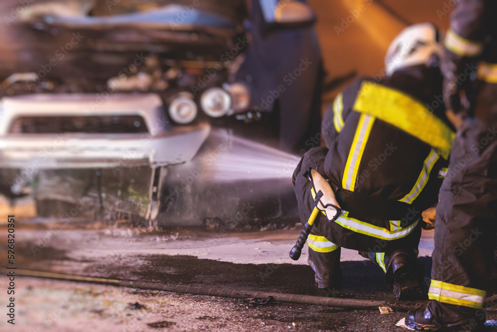 Group of fire men extinguishing and put out burning car crash after ...