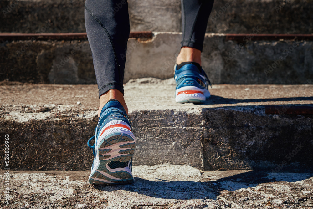 Male sprinter wearing running shoes at concrete stairs background ...