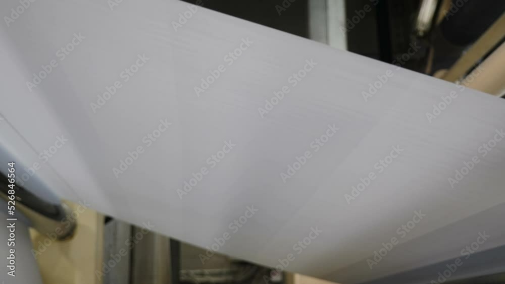 Industrial rollers with paper moving through them. Rolling conveyor ...