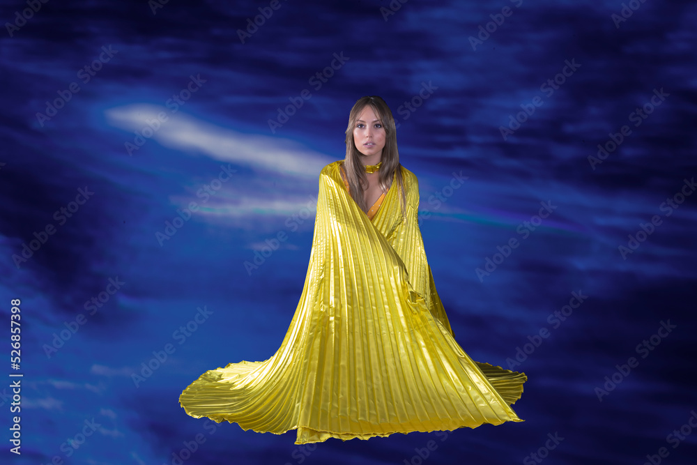 mujer joven vestida de amarillo posando con alas de Isis de color ...