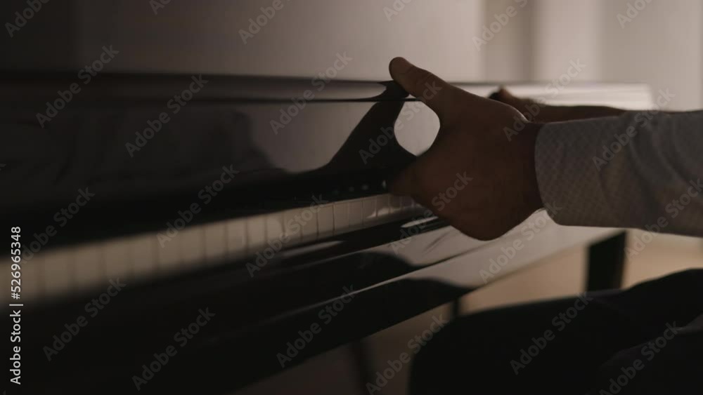 Pianist closing the piano keyboard after last music note on a cozy ...
