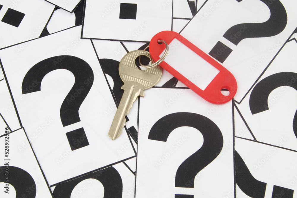 Real estate faq concept. Key with red label on question marks ...