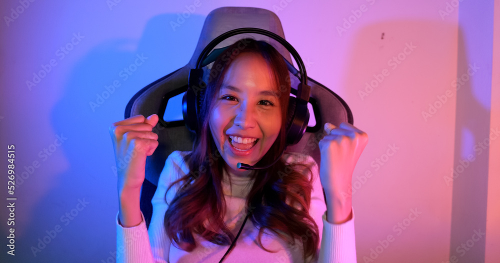 Winner gamer portrait, Young woman wearing headphones playing computer ...