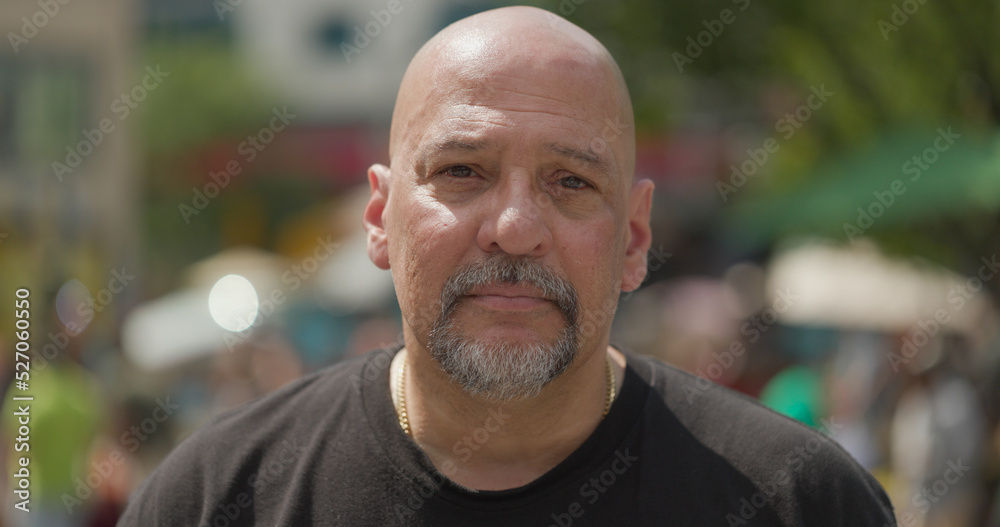 Mature Hispanic man on city street serious angry sad face portrait ...