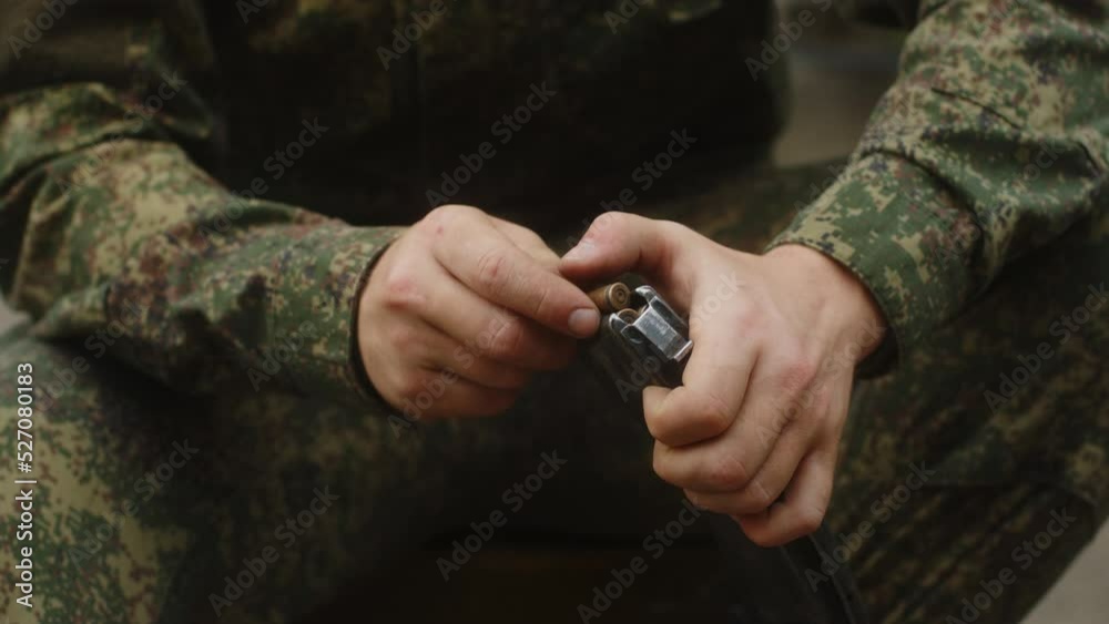 A Russian military man loads cartridges into the magazine of a ...