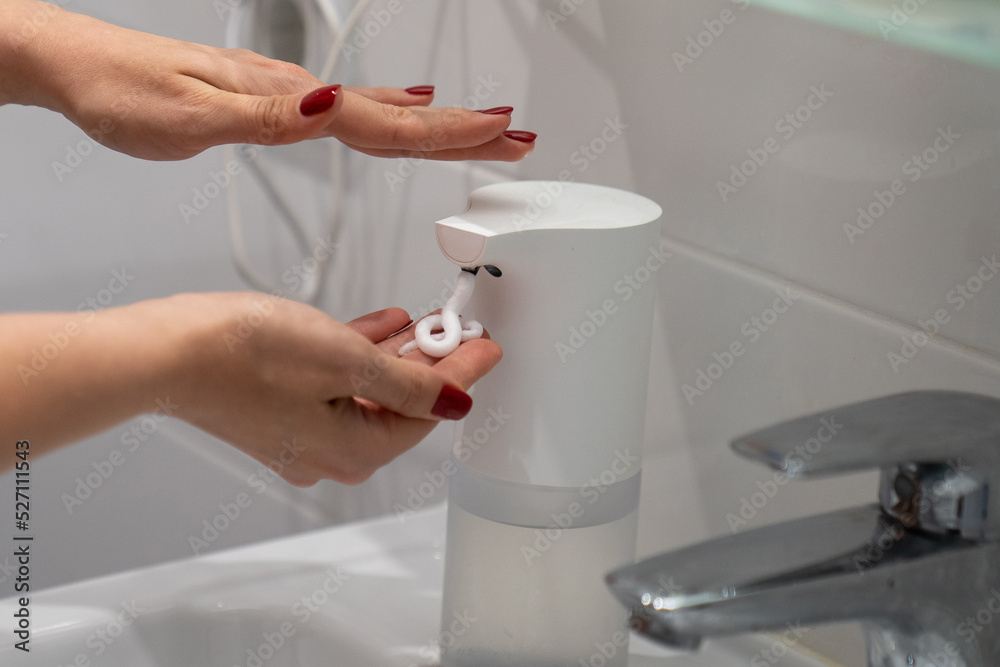 automatic sensor touchless soap dispenser, close up woman washing hands ...