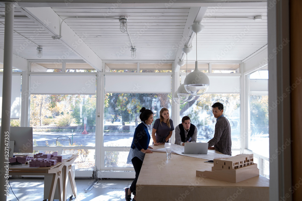Architects meeting reviewing blueprints at table in office Stock Photo ...