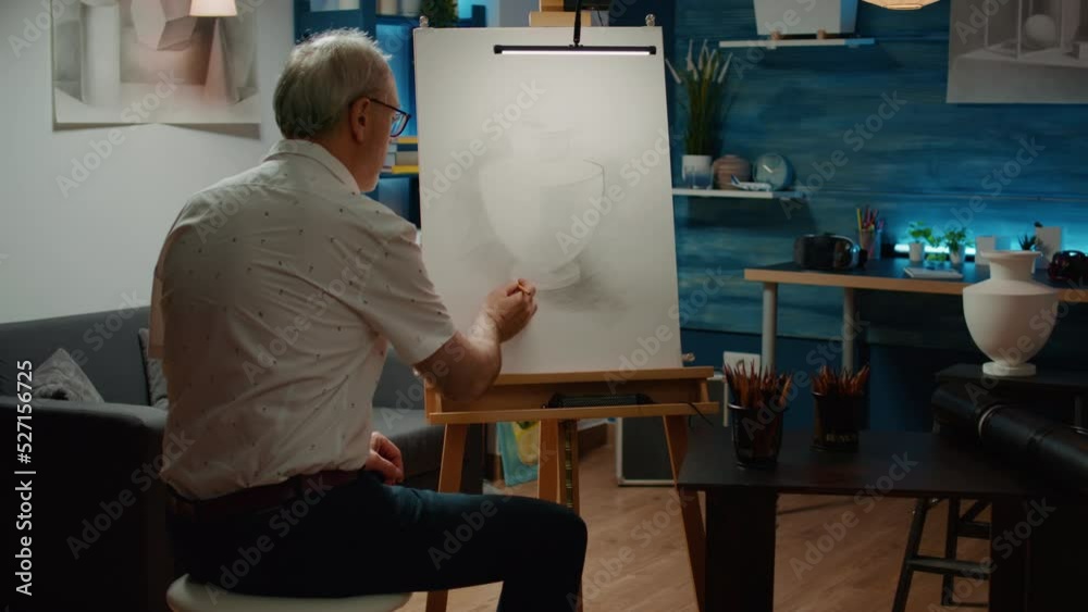 Senior artist using pencils to draw artwork of vase model on white ...