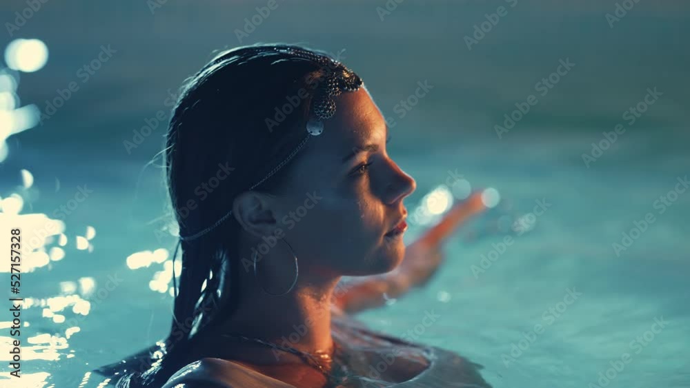 Gorgeous woman in pool water with smoke background. Attractive gypsy ...