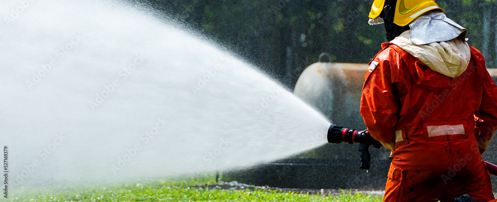Foto de Fire man spray water from hose for fire fighting. Firefighter ...