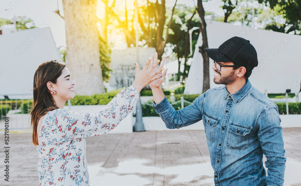A girl and a guy shaking hands on the street. Two young smiling ...