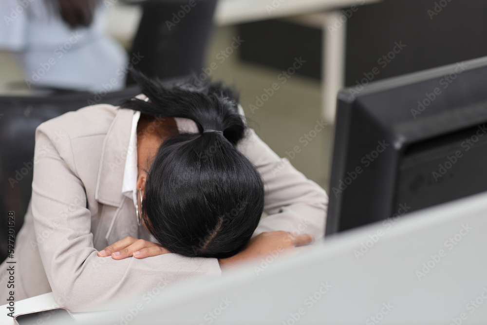 Adult asian businesswoman sitting and lying face down on table with ...