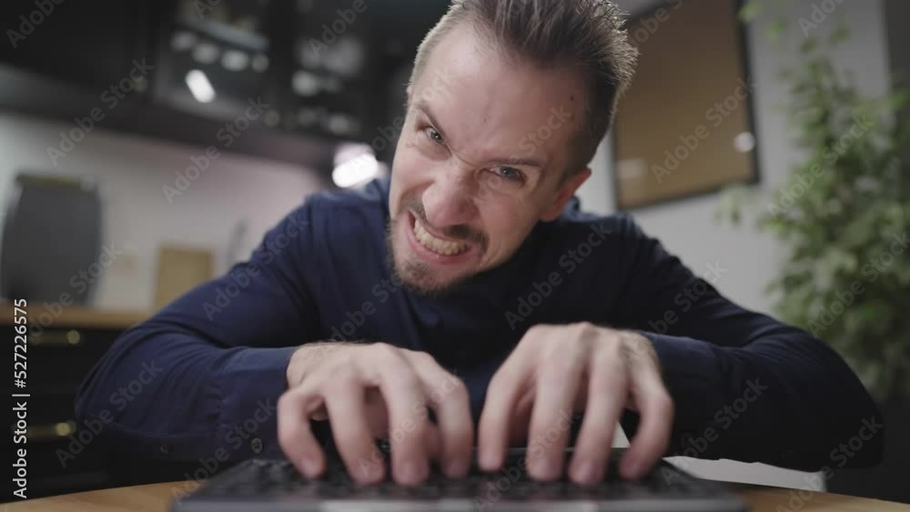 Crazy person make faces in kitchen typing on laptop keyboard point of ...