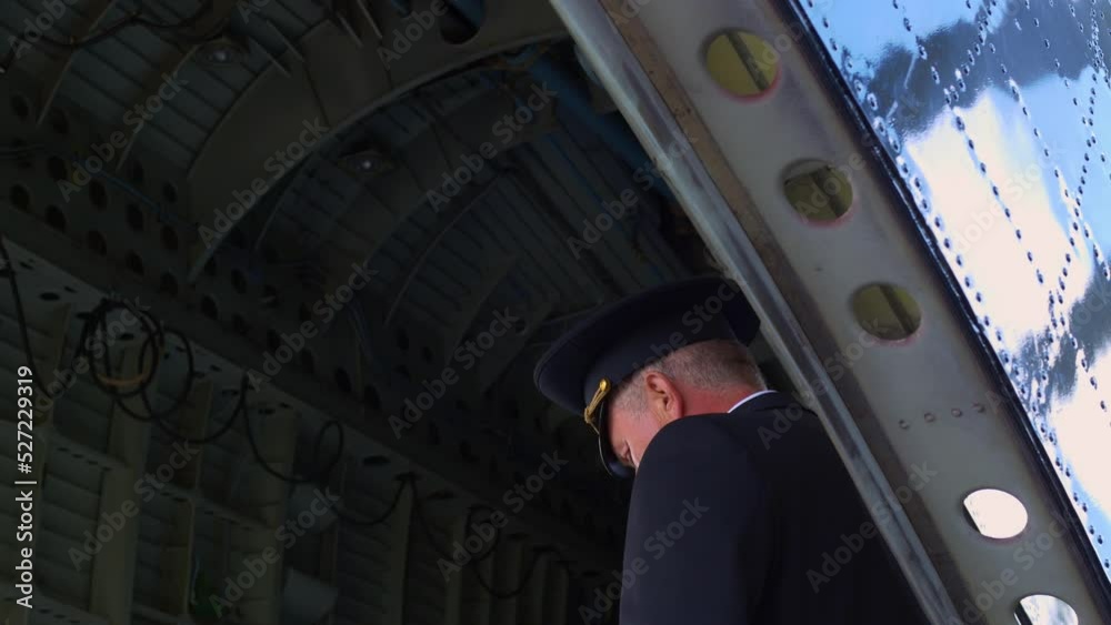 The commander in a cap stands at the rear ramp of the helicopter and ...