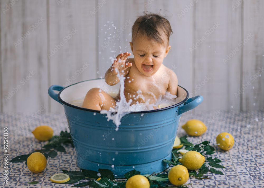 Baby splash water while bath in milk with fruit Stock Photo | Adobe Stock