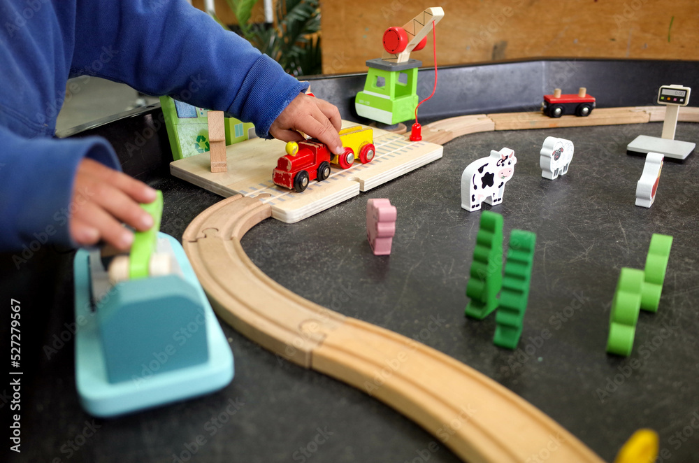 Wooden miniature train track toy set played by a toddler (3 year old ...