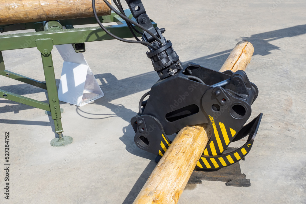 Woodworking equipment. Manipulator with tree trunk. Modern equipment ...