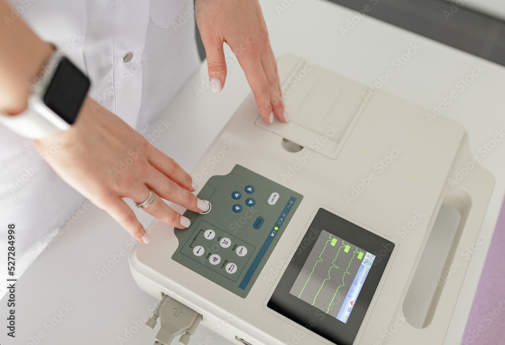 Woman cardiologist doctor makes electrocardiography procedure using ...
