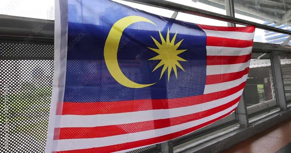 The national flag of Malaysia hangs on a railing of the train station ...