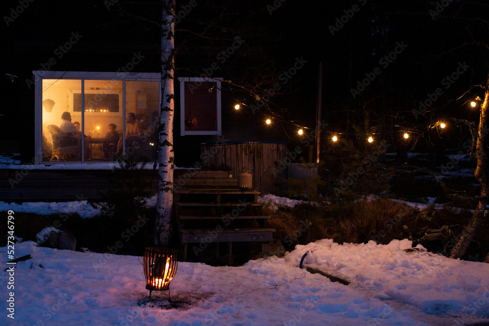 Mature men with sons seen through window of illuminated house in winter ...