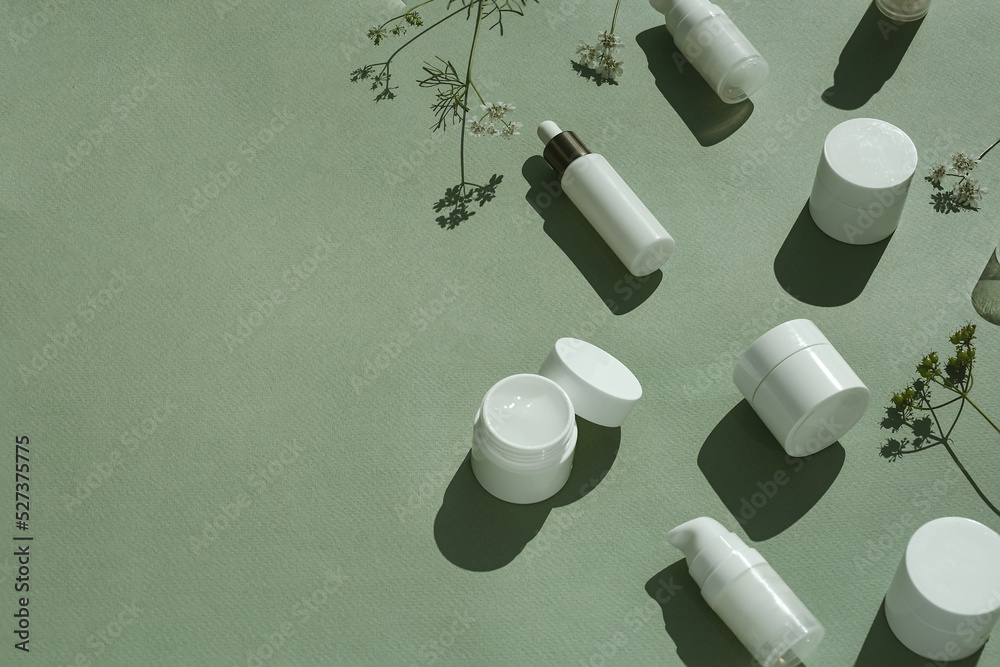 Different white packaging of cosmetics on a green background, Serum ...
