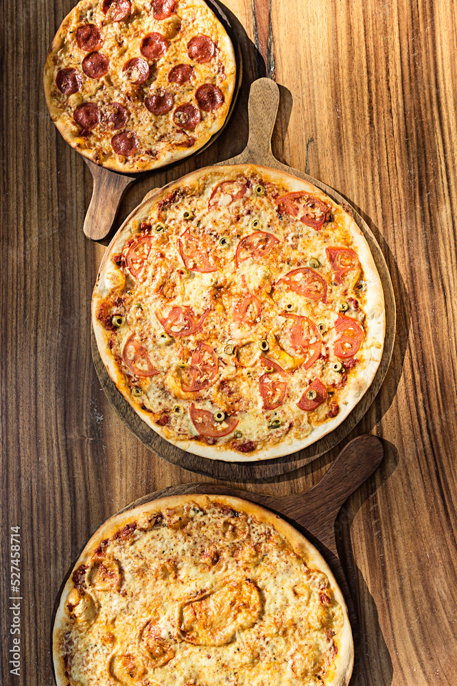 Three pizzas of different flavors. Pepperoni, cheese, potato, onion ...