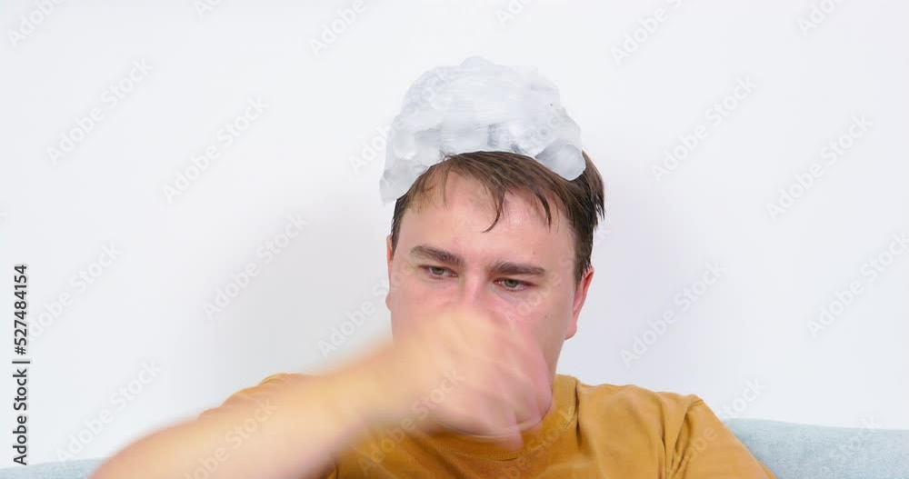 Man sits on couch boils with anger makes cold compress cool emotions ...