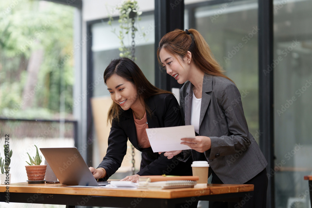 Two Asian Beautiful Business woman working and analysis financial ...