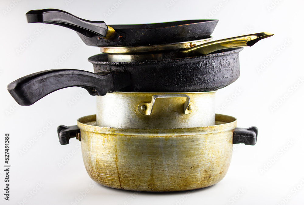 Dirty old utensils in a stack of metal on a white background, isolated ...