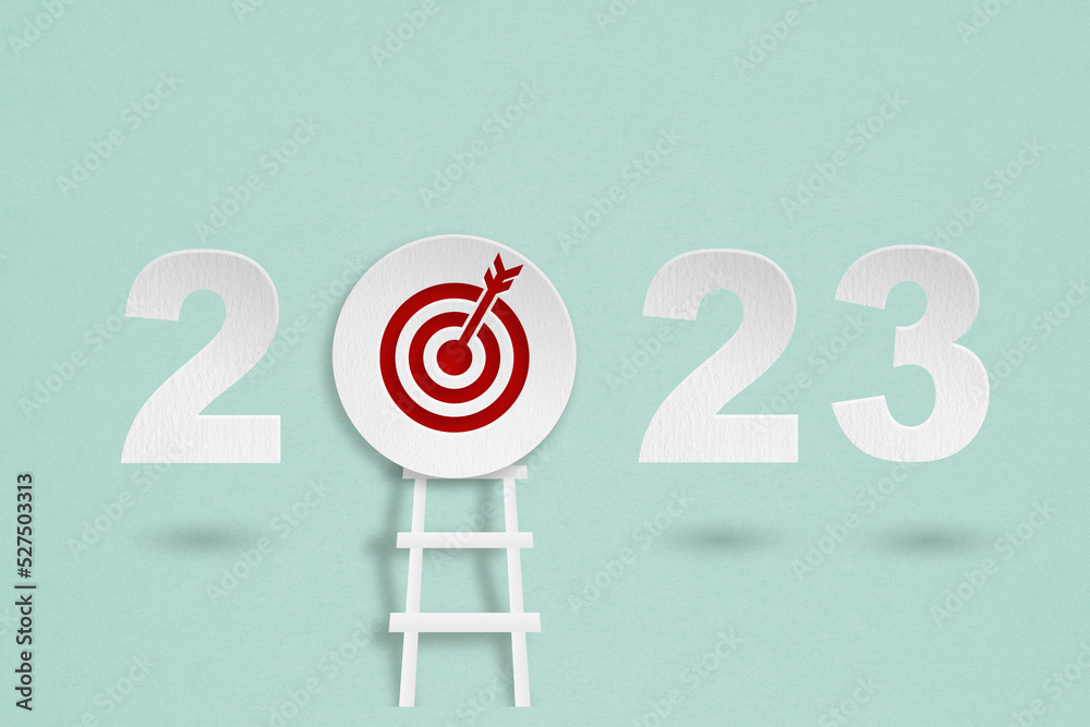 2023 year with red target dartboard paper cut and ladder for setup ...
