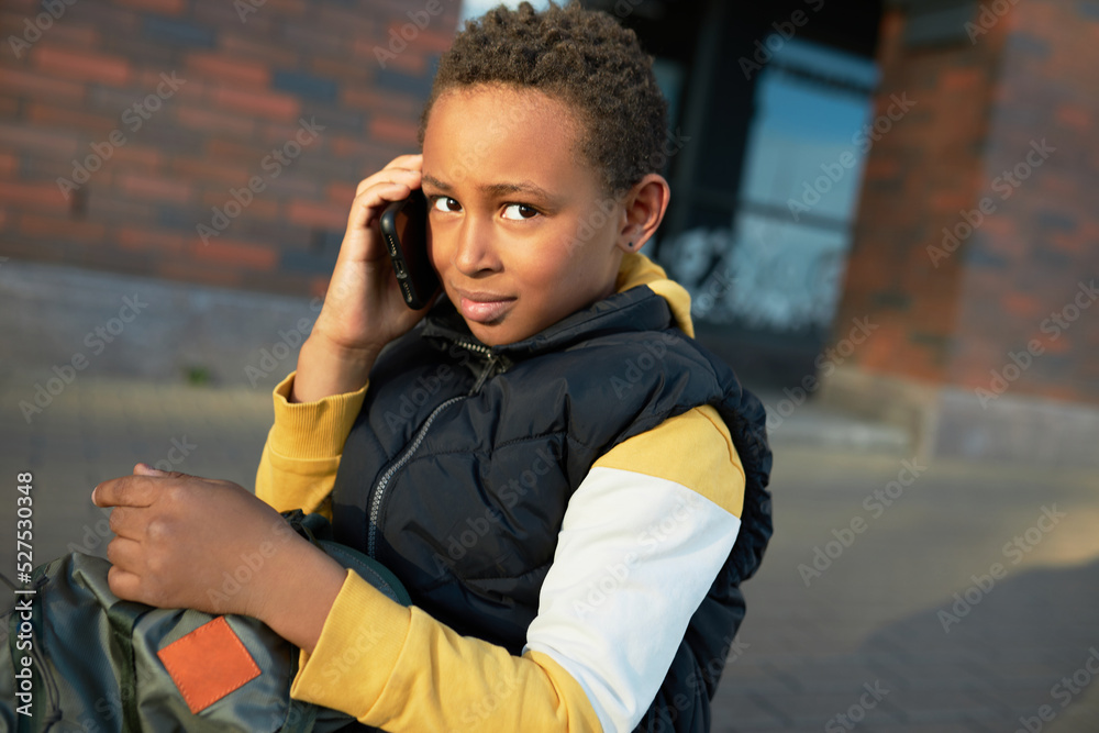 Closeup picture of black kid boy talking on phone with his dad, looking ...