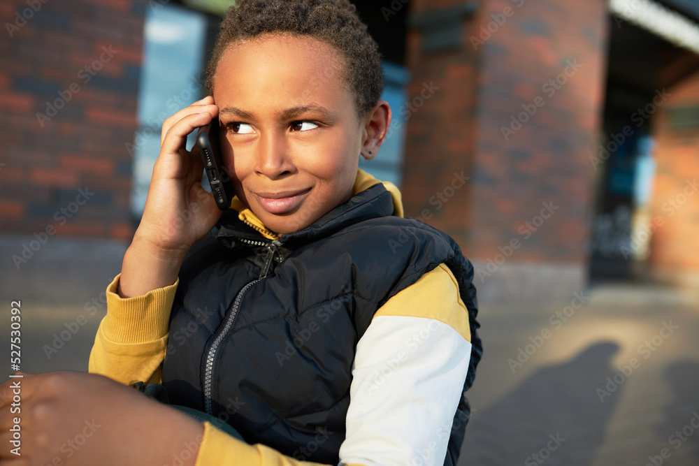 Tricky boy kid of black ethnicity having phone conversation with his ...