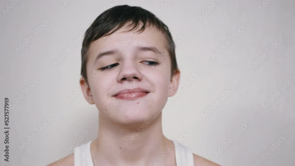 A Smiling Boy with Lowered Eyelids Rotates his Eyes in Different ...