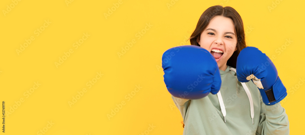 aggressive child punching in boxing gloves on yellow background, sport ...