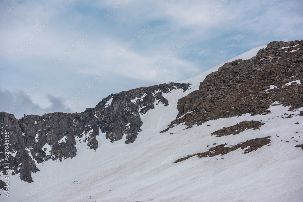 Atmospheric landscape with high snow mountain with sharp rocks under ...