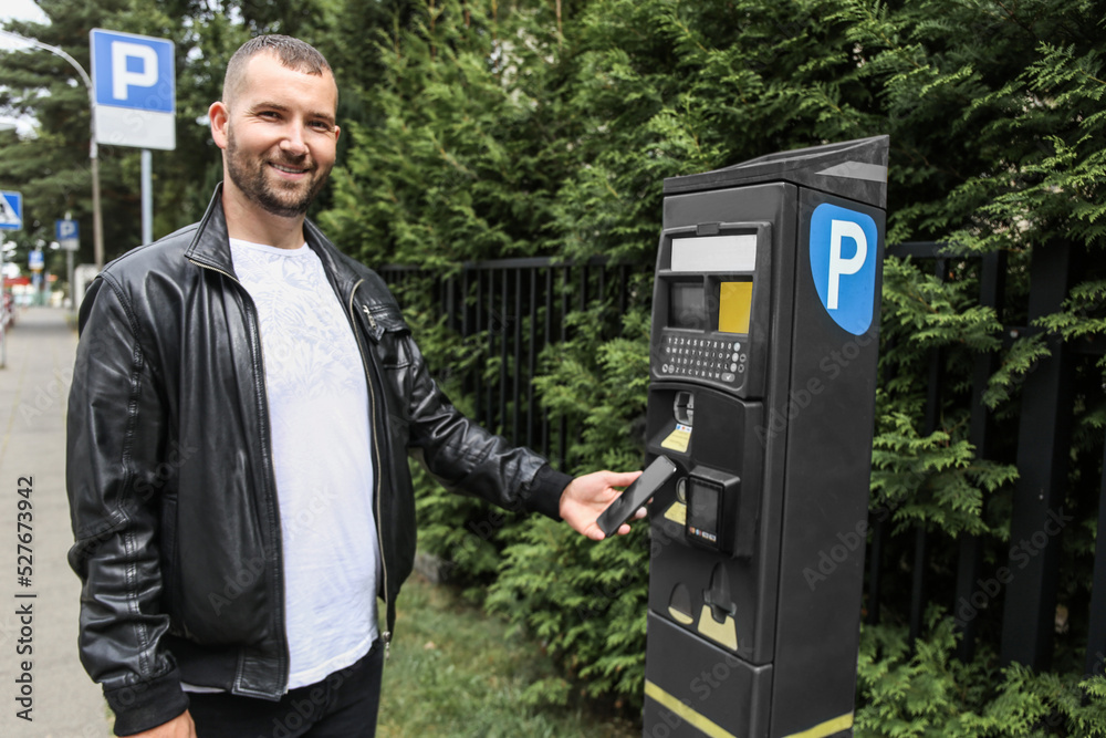 happy man pays for his parking space at the parking meter Stock Photo ...
