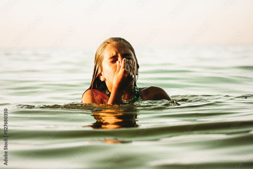Child drowning in water holding hand above a surface of green water ...