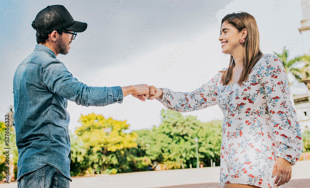 A guy and girl shaking hands on the street. Two young smiling teenagers ...