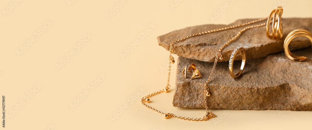 Granite stones and stylish jewelry on beige background with space for ...