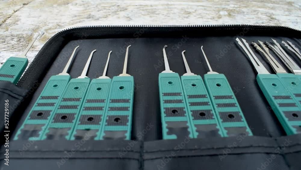 Lockpicking tools kit in a pouch on white wood surface. Lockpick tools ...