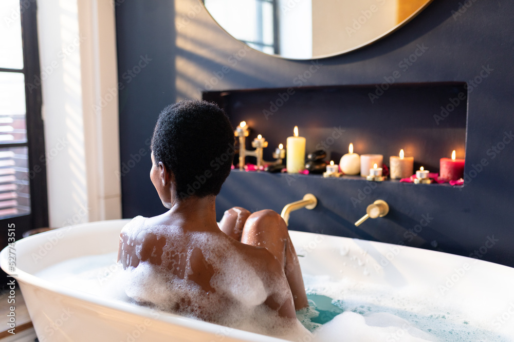 Naked African American Young Woman Relaxing In Bath Tub While Looking
